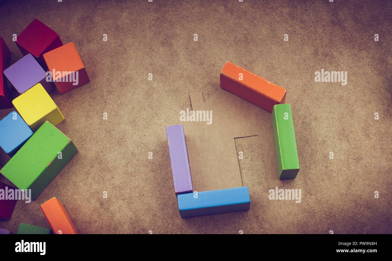 House shape formed out of building blocks on a brown background Stock ...