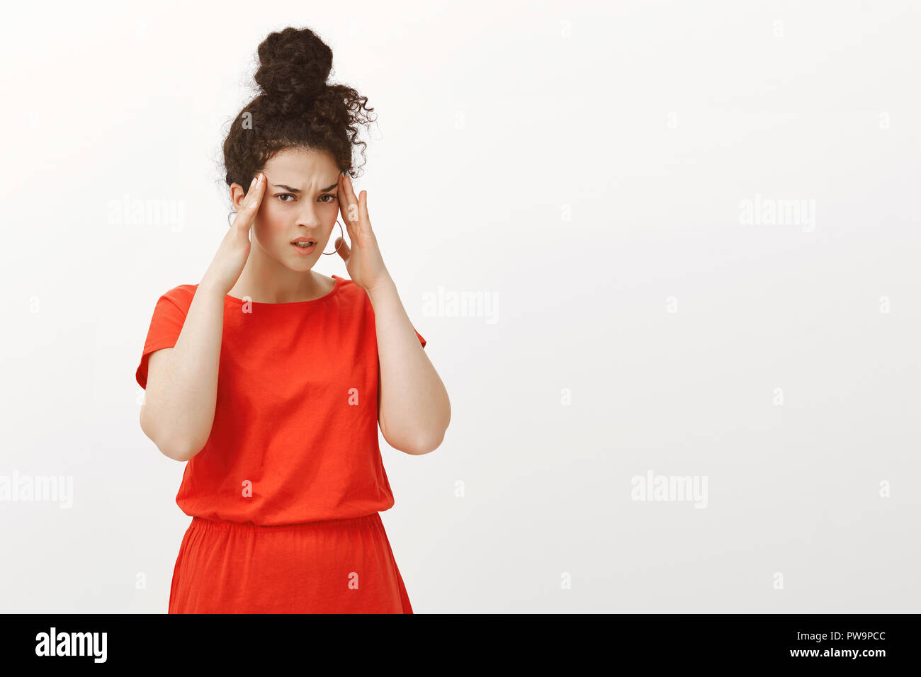 Portrait of unfocused troubled caucasian girl in red dress, holding ...
