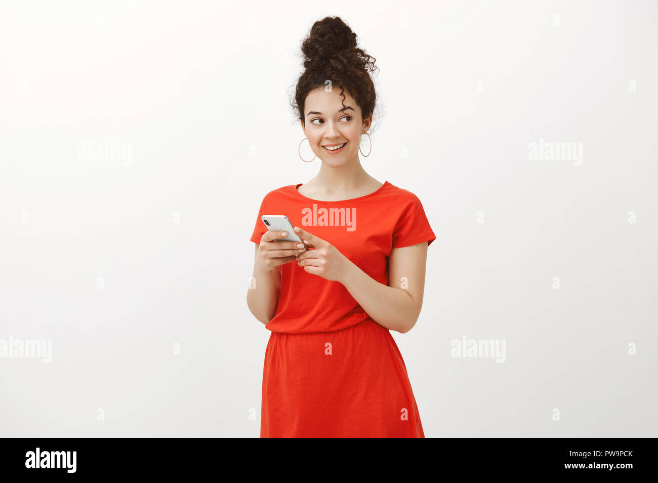 Intrigued friendly european woman in stylish red dress, holding brand ...
