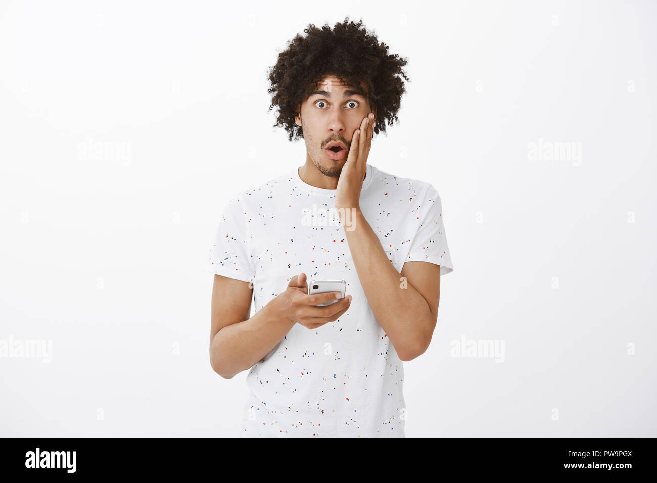 Portrait of shocked stunned cute male model with afro hairstyle and ...