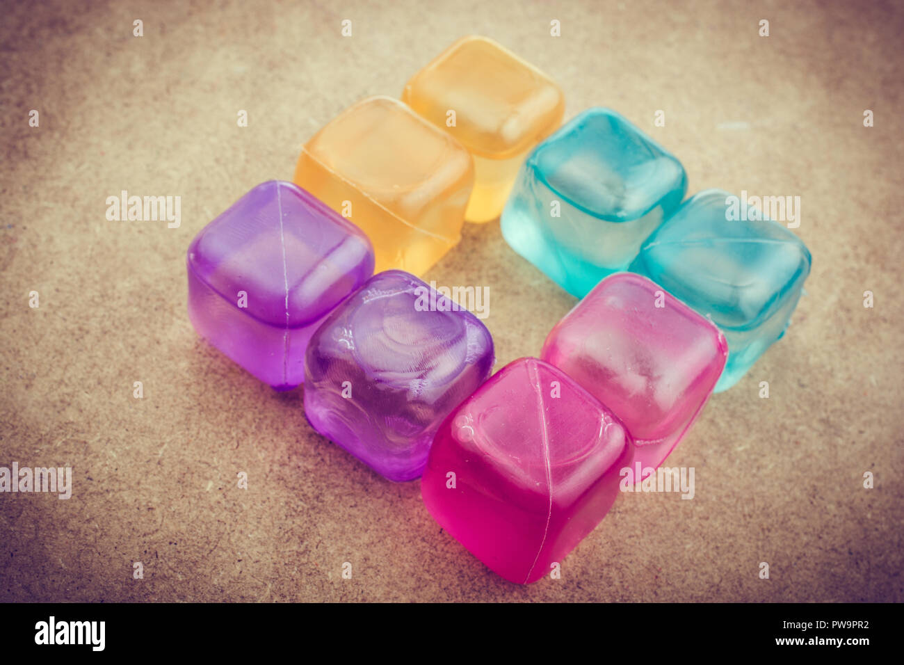 Fake colorful ice cubes on a brown background Stock Photo - Alamy