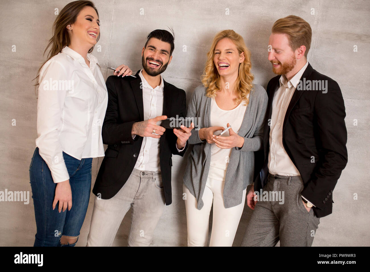 Group of young good looking people standing together over wall ...