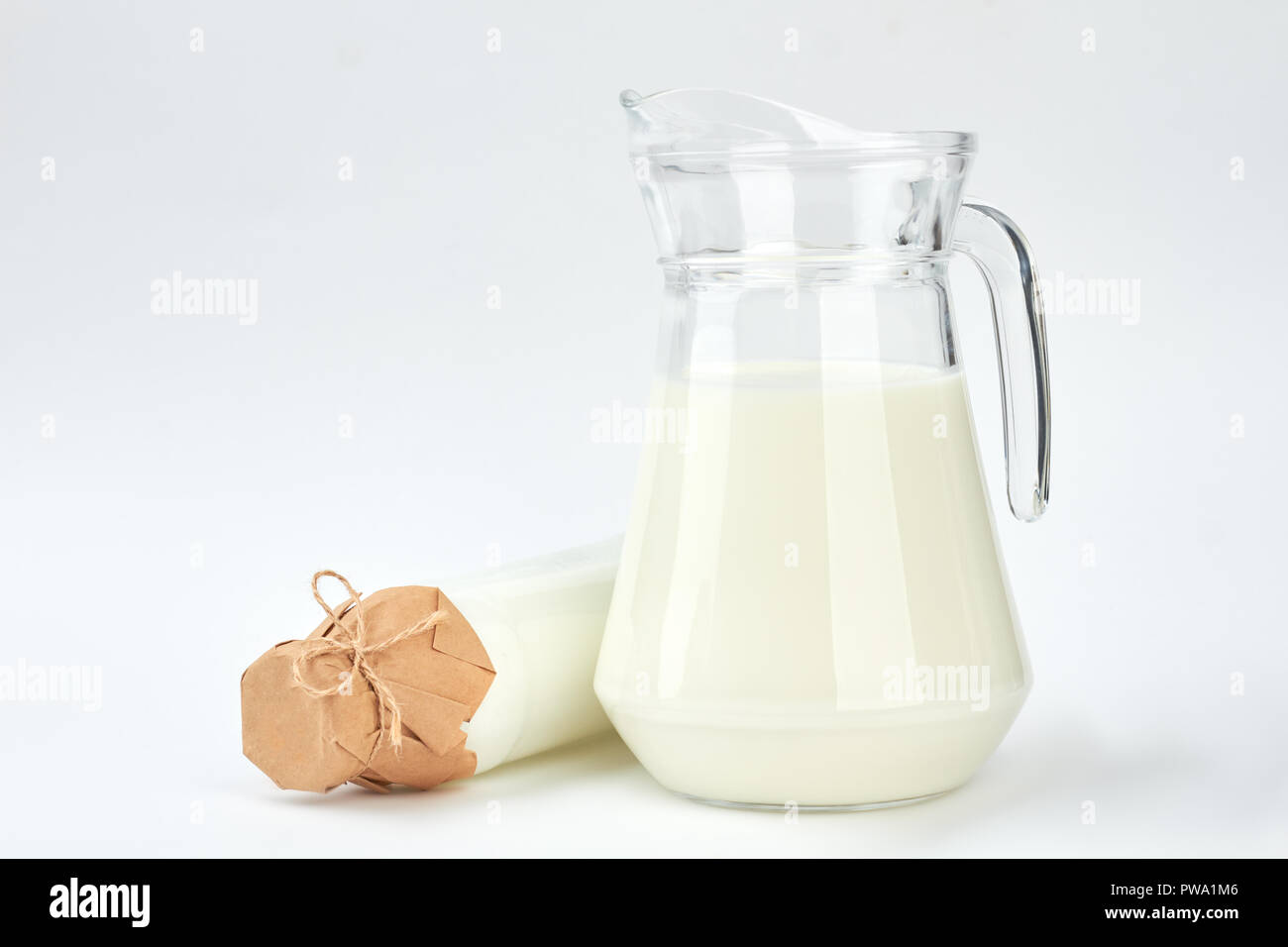 Healthy milk products on light background. Fresh milk in bottle and jug ...