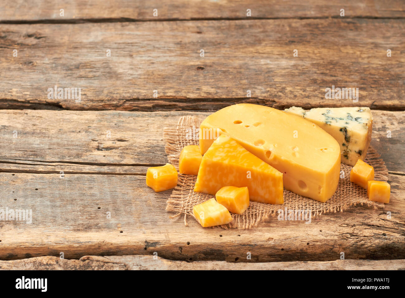Dairy products on rustic wood. Assorted cheese on grunge wooden boards ...
