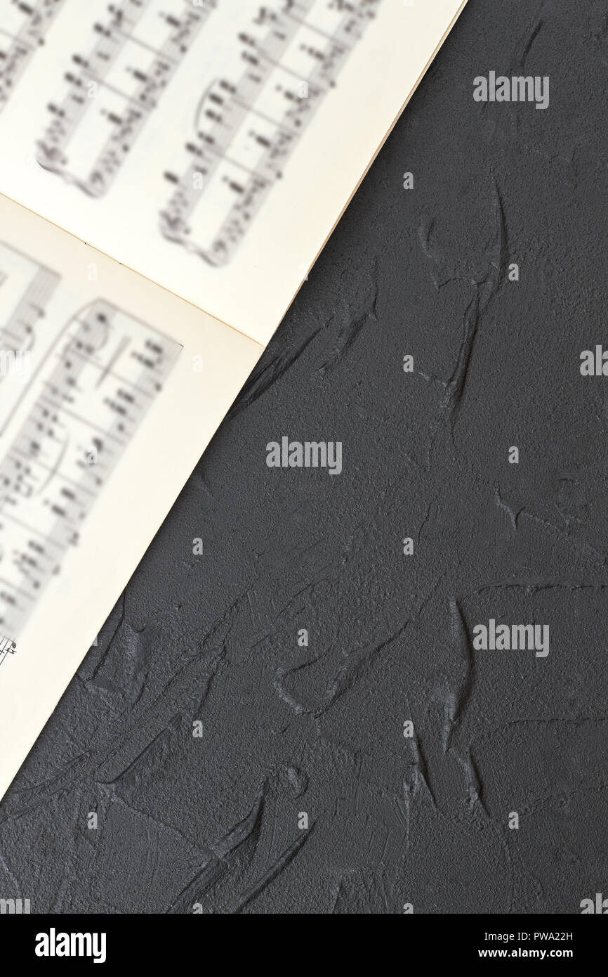 Black slate background with musical notes. Musical note sheets on dark ...