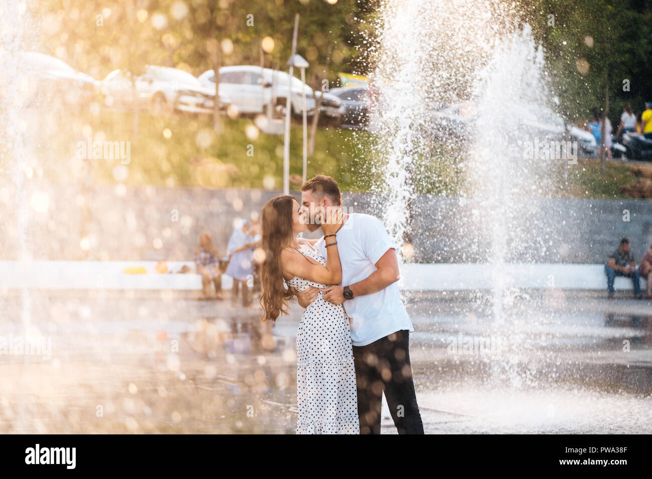 Handsome guy and beautiful girls kissing on the background of a ...