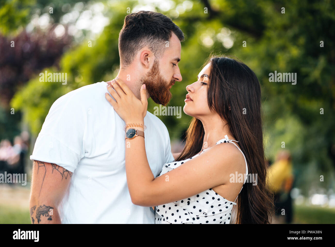 Handsome guy and beautiful girls kissing in the park. Love concept ...