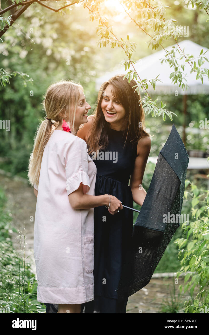 Two girls in a summer park with an umbrella Stock Photo - Alamy