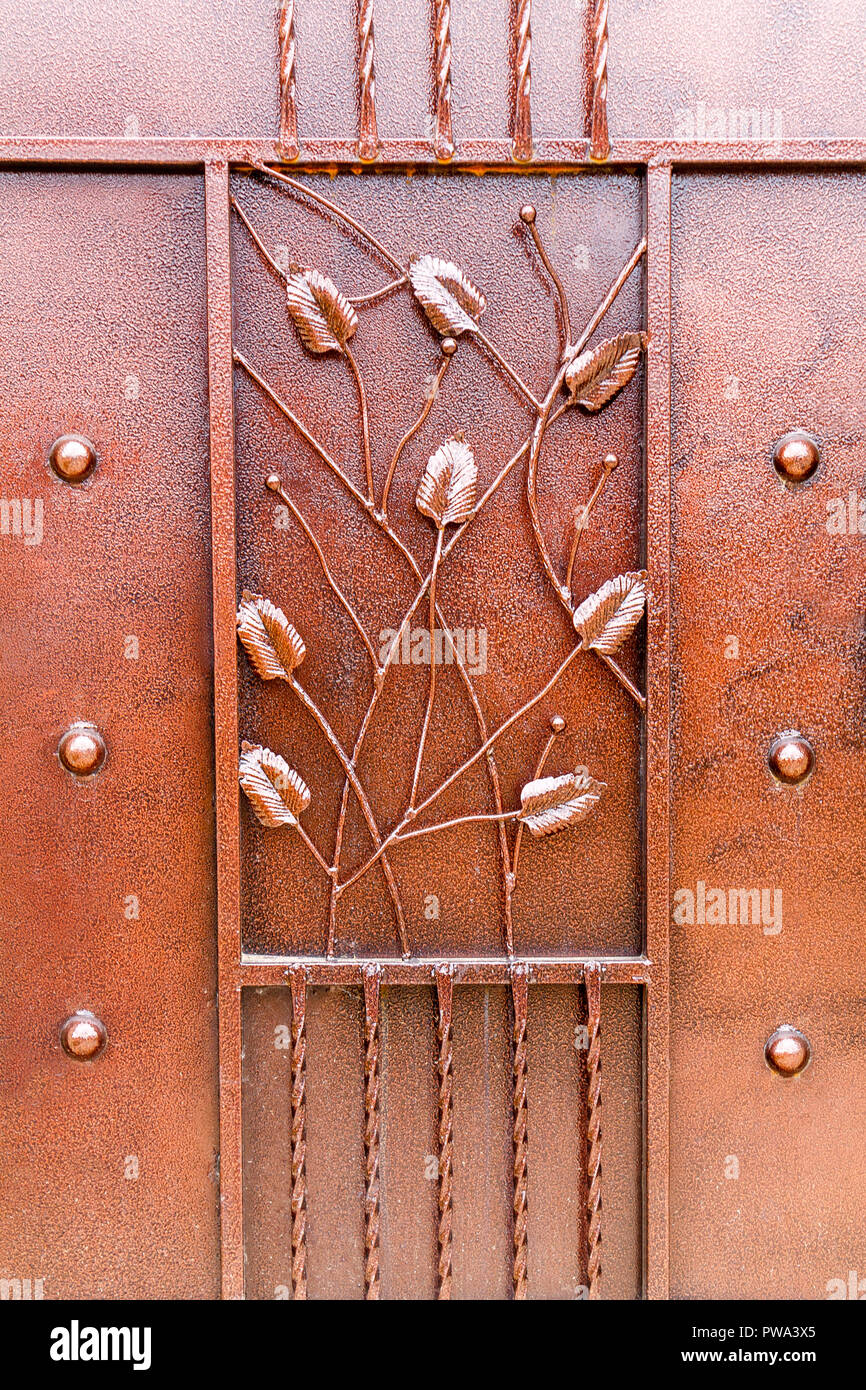 Decorative ornament of metal branches, leaves and straight lines on a ...