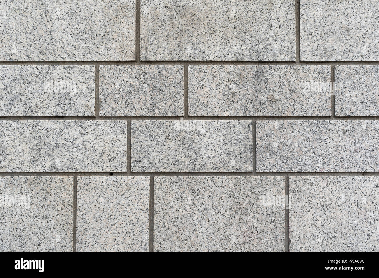 Grey granite brick wall background texture with different sized ...