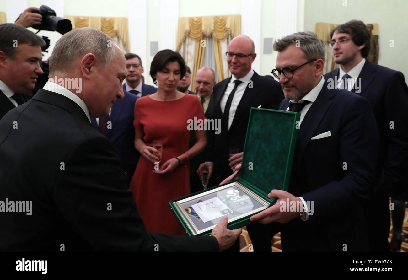 Russian President Vladimir Putin is presented with a commerative stamp ...