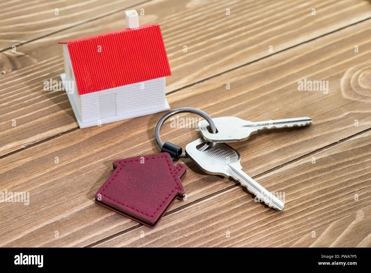 key chain with house symbol and keys on wooden background,Real estate ...