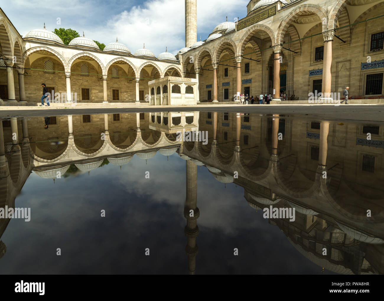 The Suleymaniye mosque courtyard reflected in water showing ablution ...