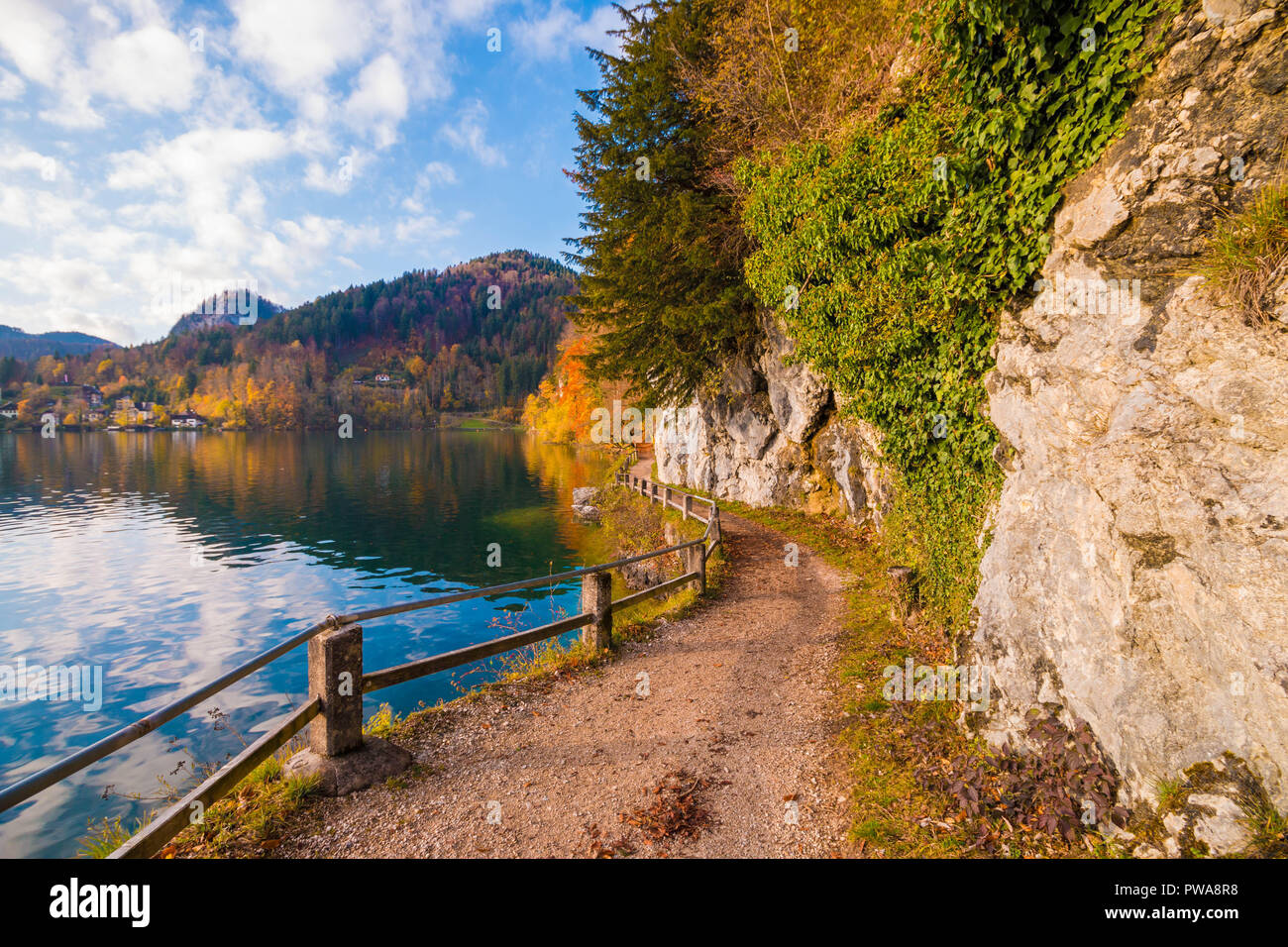 Walking path with a fence along alpine lake Wolfgangsee in austrian ...