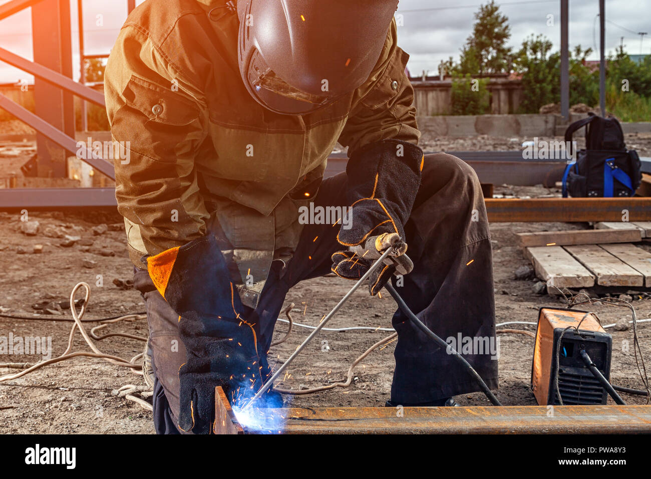 Close up welder weld metal pipe at construction site. A builder in ...