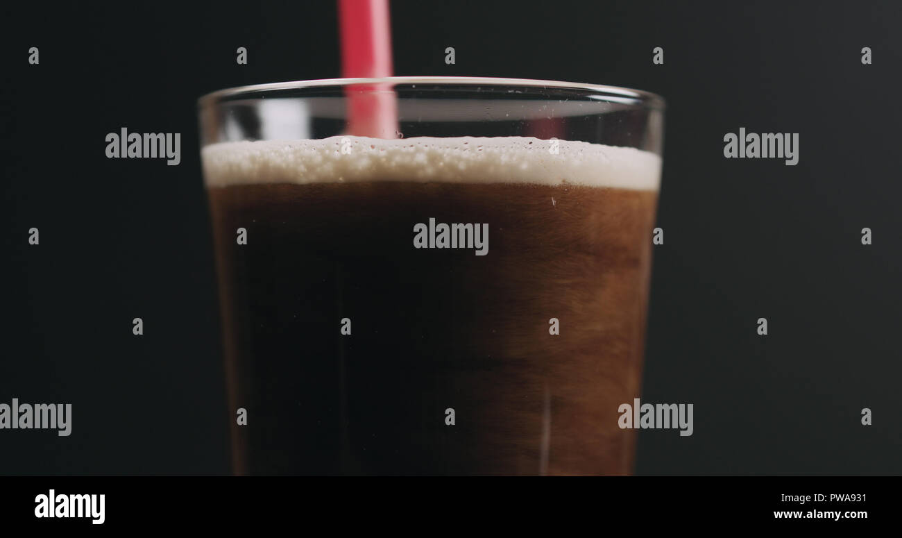 Closeup swirl dark stout beer with bubbles over black background, wide ...