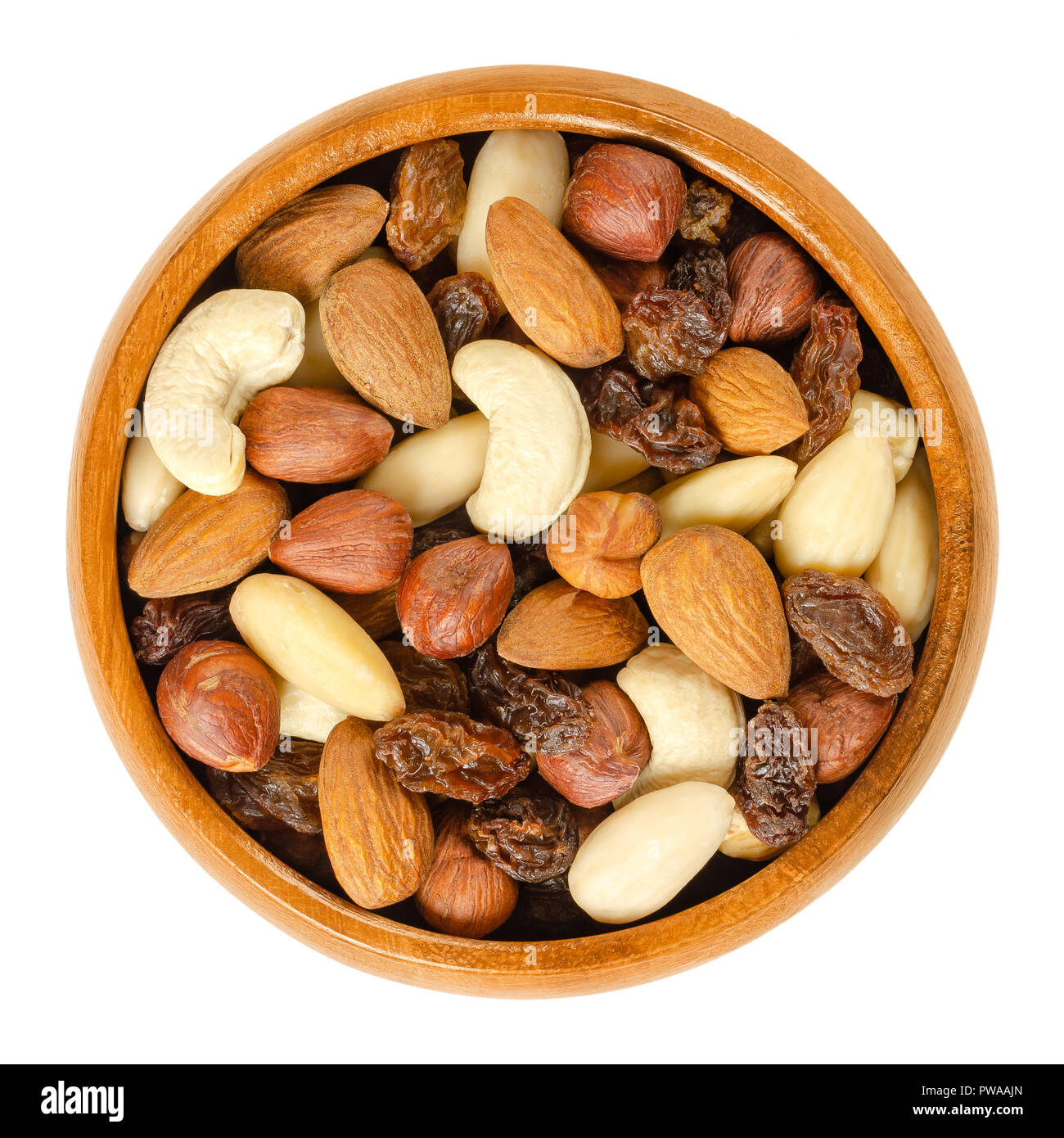 Nuts and raisins in wooden bowl. Snack mix of dried almonds, hazelnuts ...