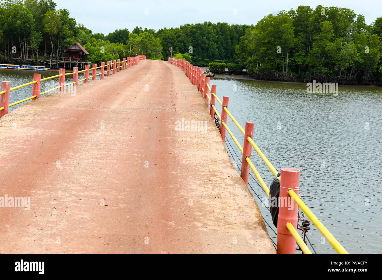 Old reddish brown concrete bridge cross over swamp area located at ...