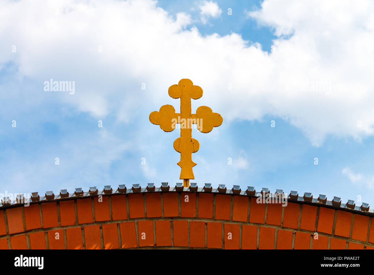 The yellow Christian cross adorns the structure of the temple against ...