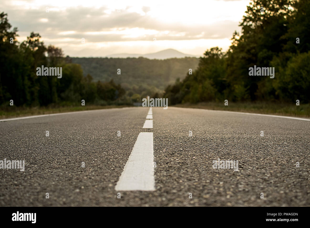 mountain road receding into the distance, the sunset, the horizon of ...