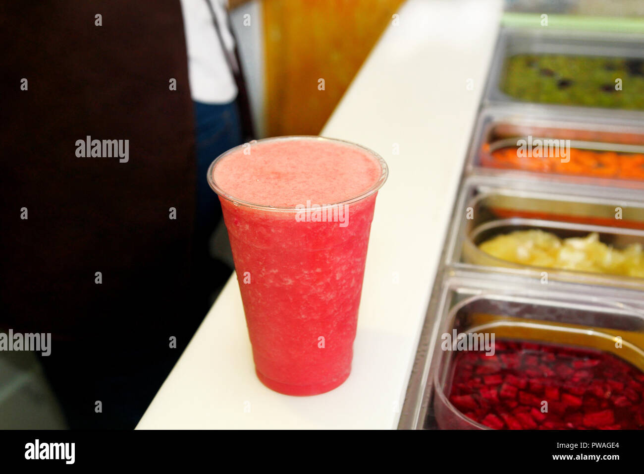 Fruit smoothie ready for sales in plastic cup with straw. Take away ...