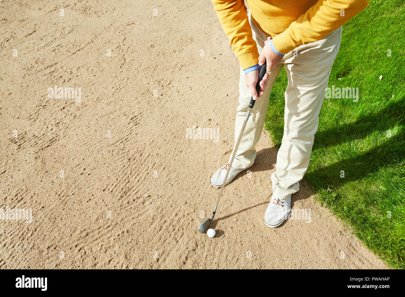 Overview of active man holding golf club in front of himself close to ...