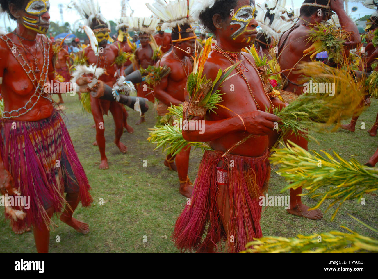Colourfully dressed and face painted women dancing as part of a Sing ...
