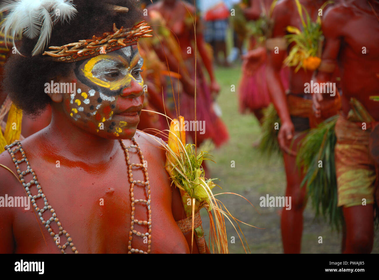 Colourfully dressed and face painted women dancing as part of a Sing ...