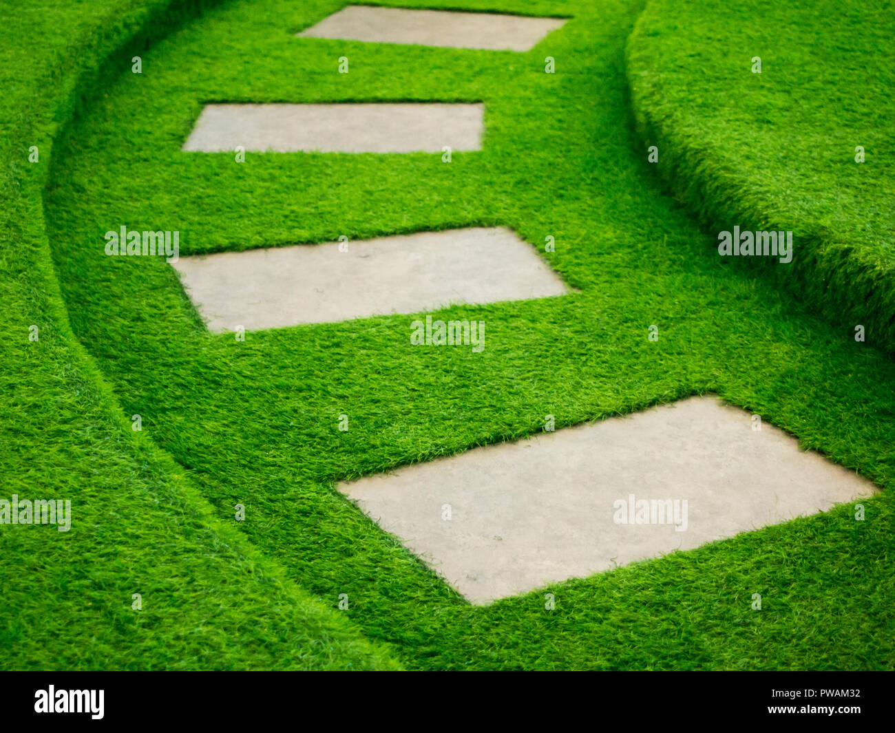Artificial green grass walk way with concrete plate background Stock ...