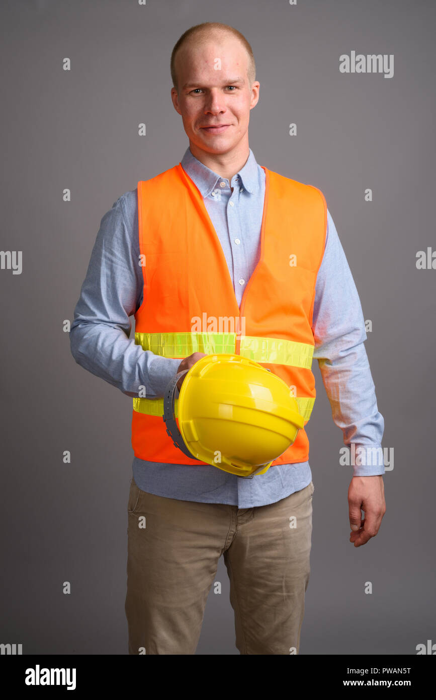 Bald man construction worker against gray background Stock Photo - Alamy