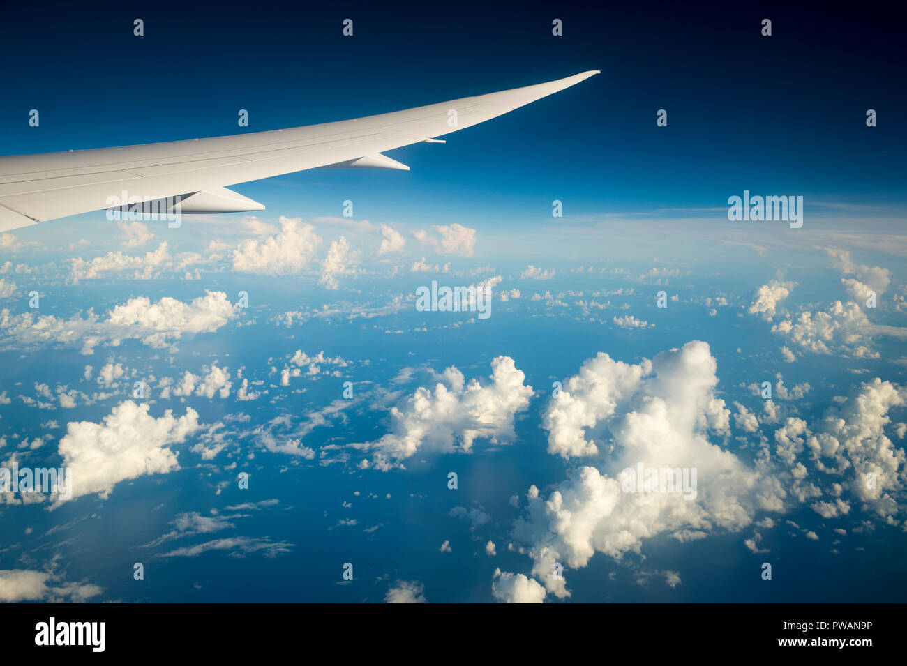 Travel background of clean modern airplane wing over bright blue sky ...