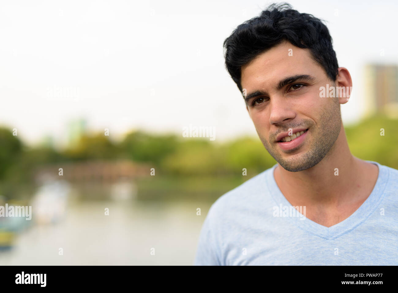 Young handsome Hispanic man relaxing in the park Stock Photo - Alamy