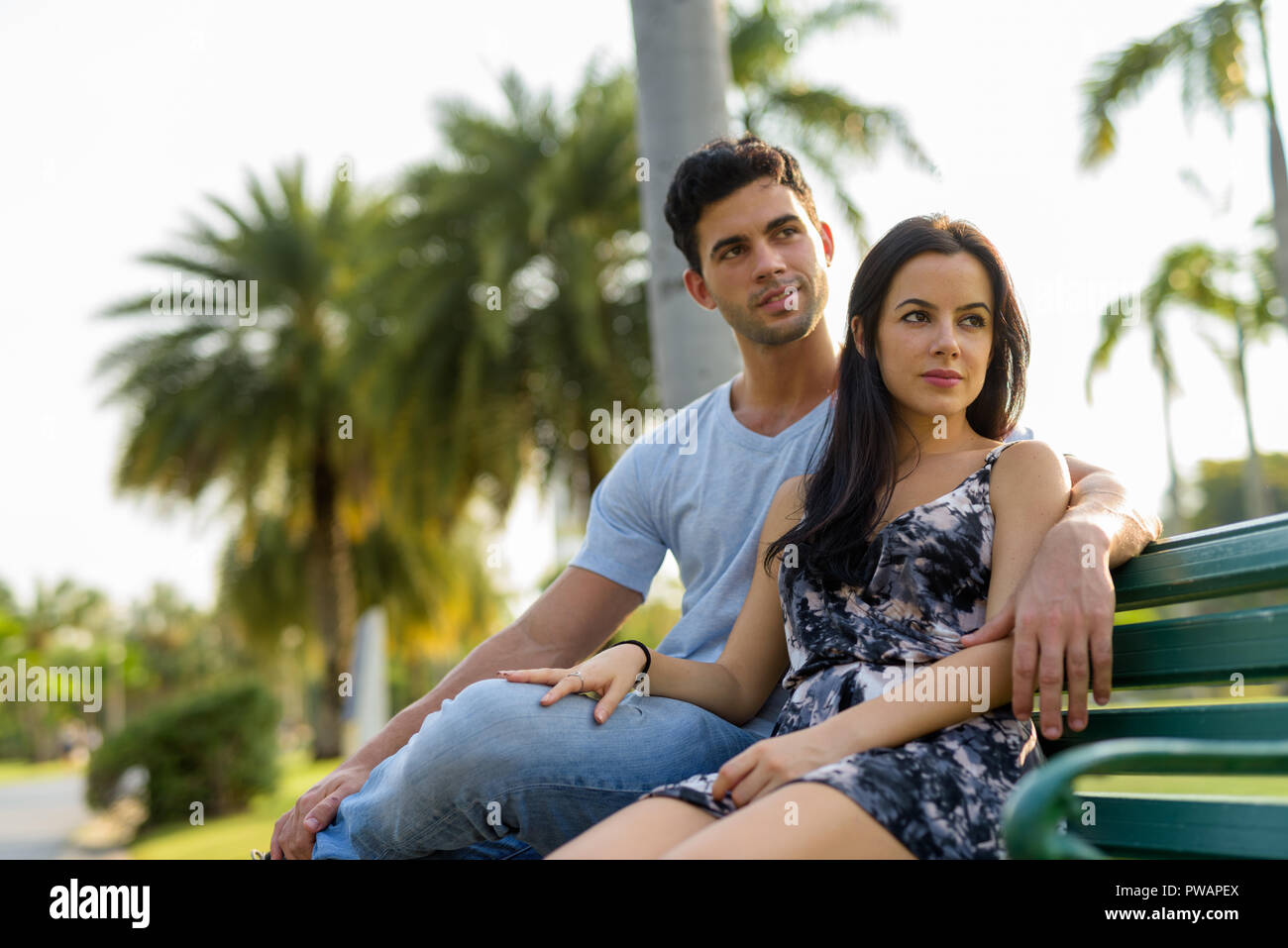 Young Hispanic couple relaxing in the park together Stock Photo - Alamy