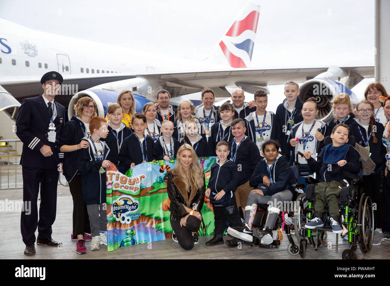 Pop singer Una Healy (front centre) with children at Heathrow Airport ...