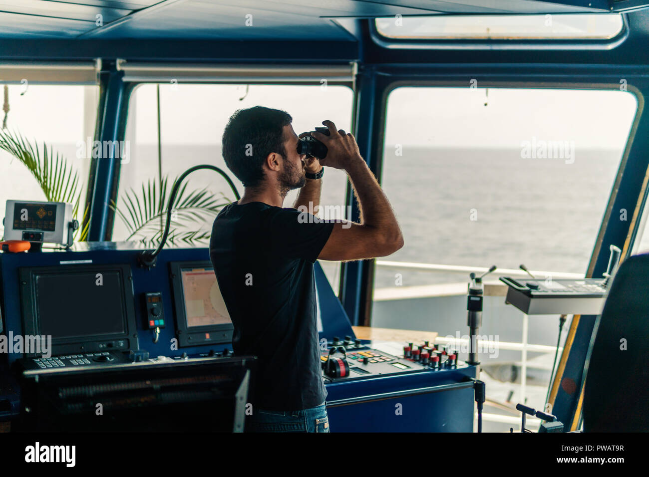 Navigational officer lookout on navigation watch looking through ...
