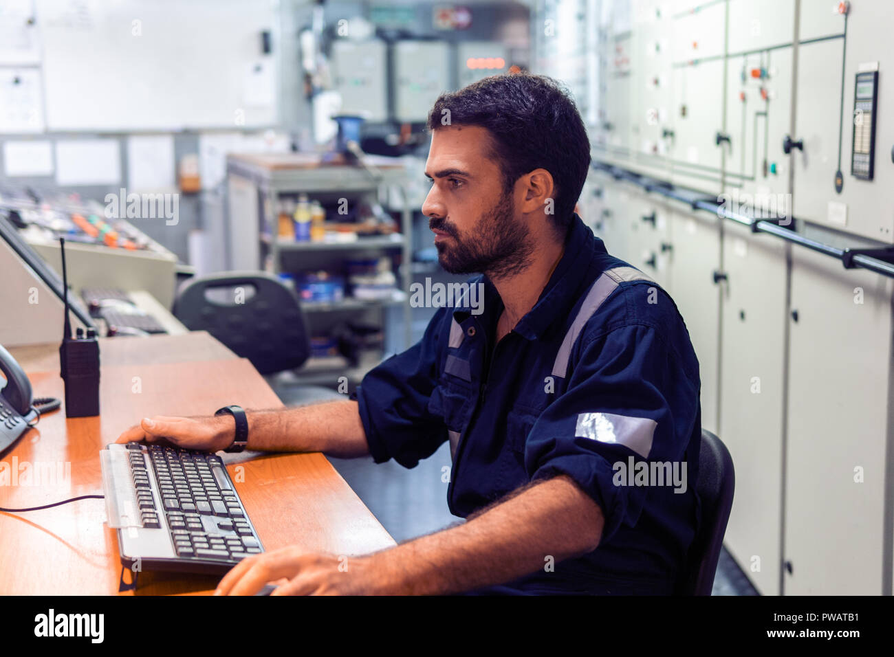 Marine engineer officer working in engine room Stock Photo - Alamy