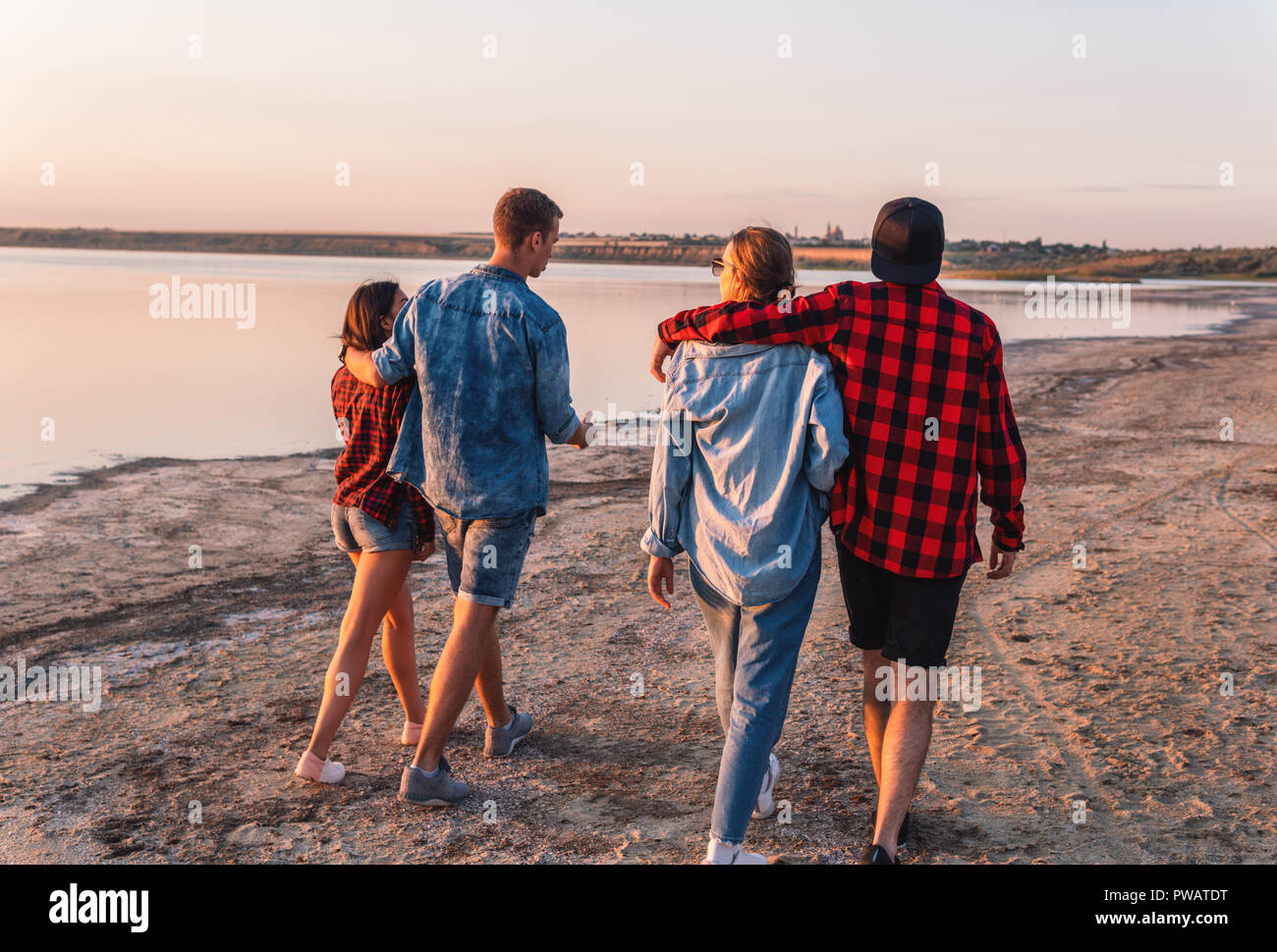 friends on beach together walking during sunset Stock Photo - Alamy