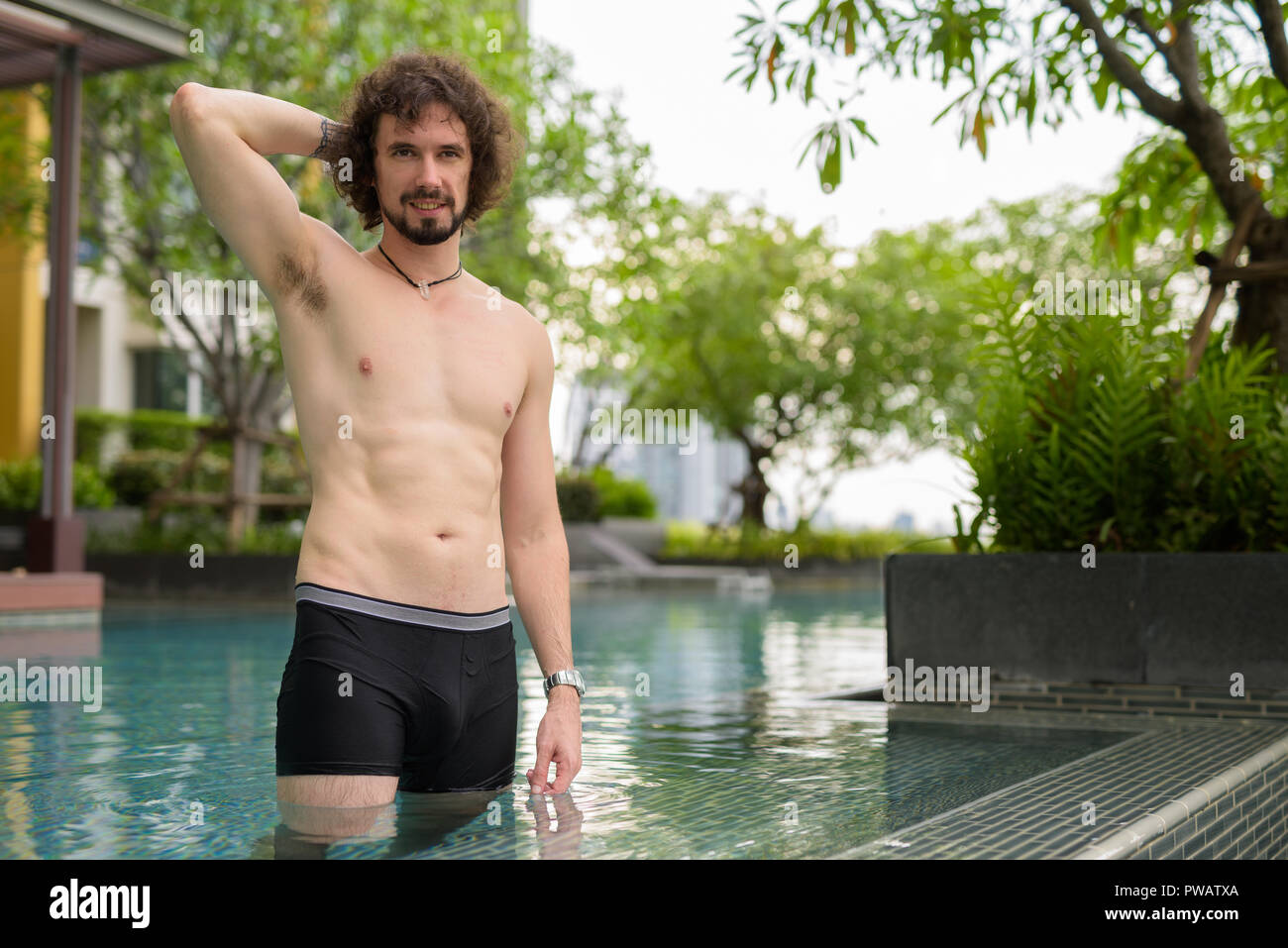 Handsome bearded man shirtless relaxing beside the swimming pool Stock ...