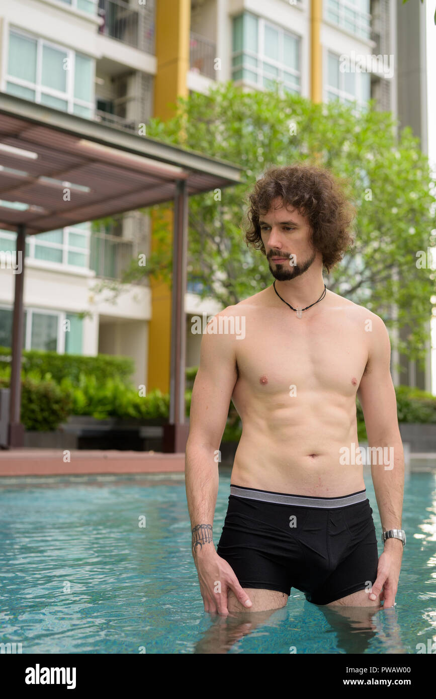 Handsome bearded man shirtless relaxing beside the swimming pool Stock ...