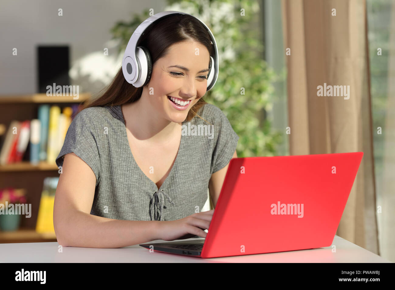 Happy girl e-learning watching video tutorials with a laptop and ...