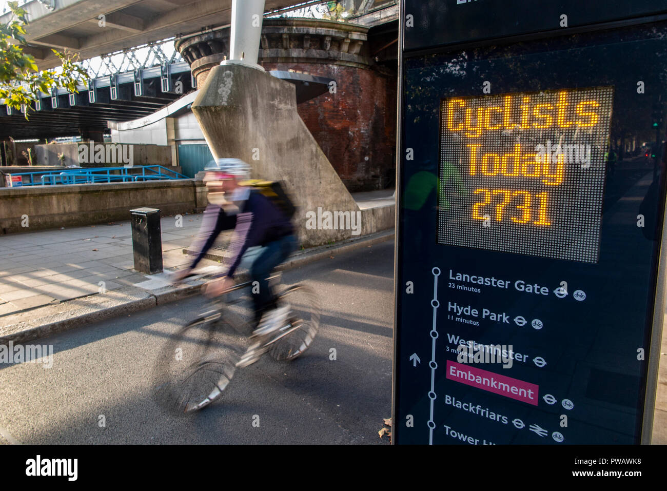Riders cycling through a digital bicycle rider counter in London Stock ...