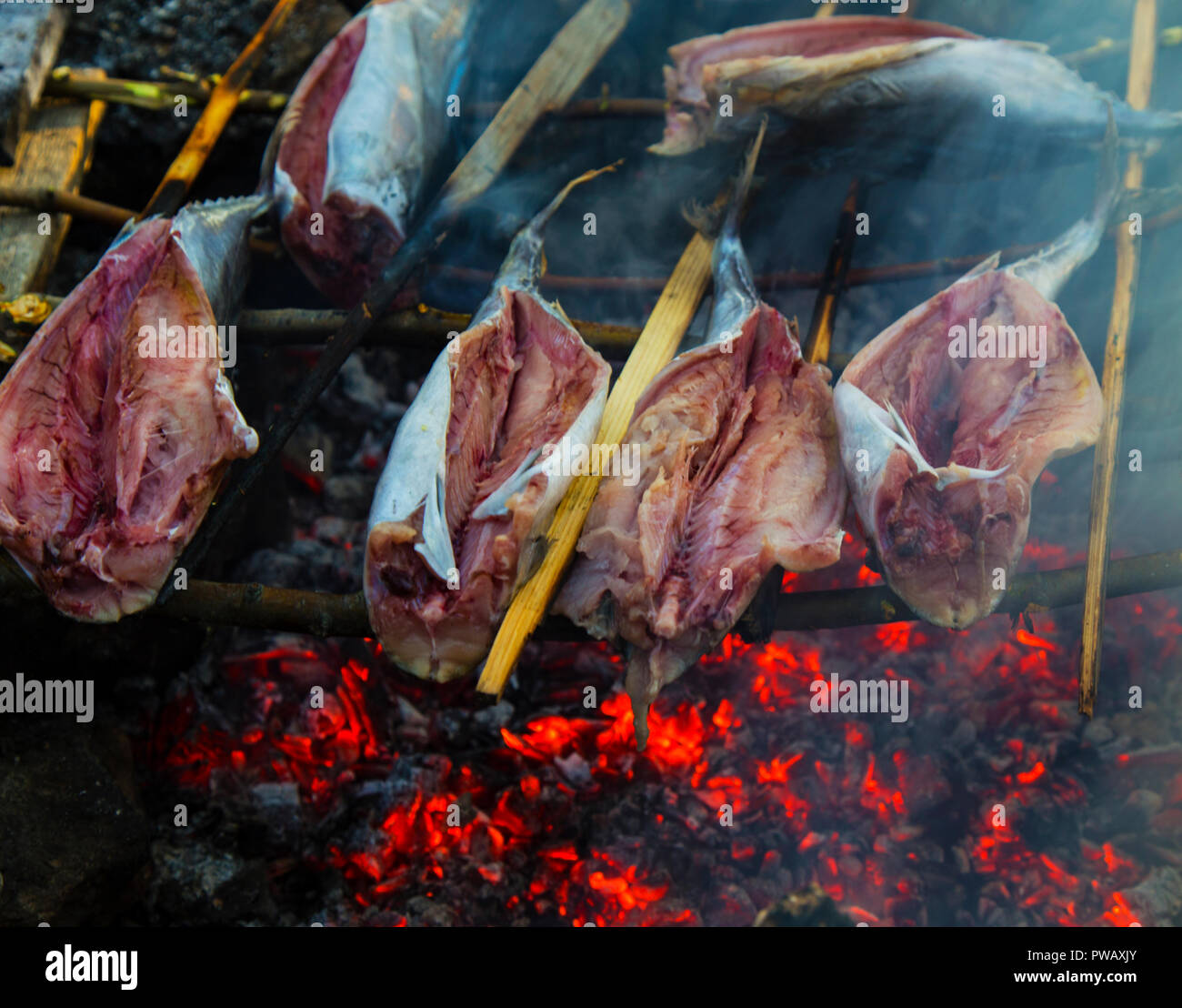 Roasting fish on fire closeup Stock Photo - Alamy