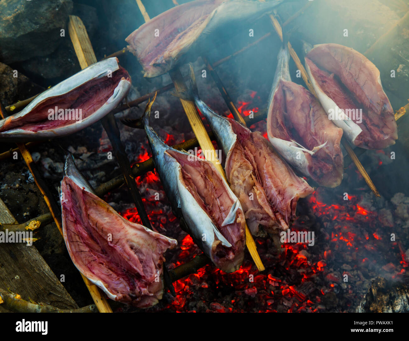 Roasting fish on fire closeup Stock Photo - Alamy