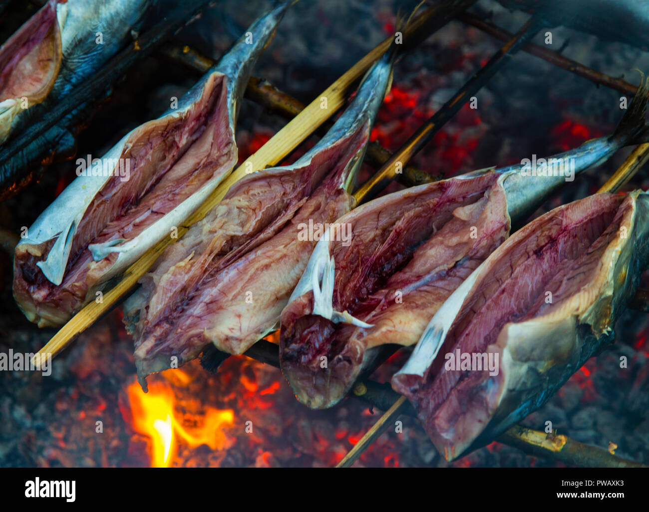 Roasting fish on fire closeup Stock Photo - Alamy