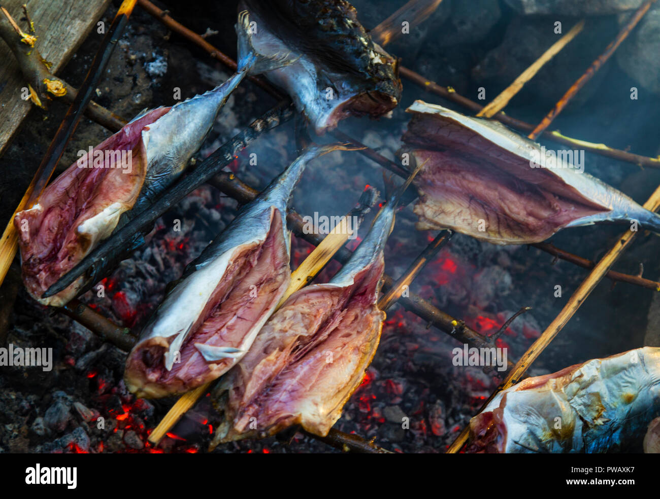 Roasting fish on fire closeup Stock Photo - Alamy