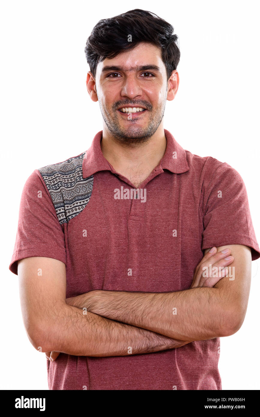 Studio shot of young happy Persian man smiling with arms crossed Stock ...