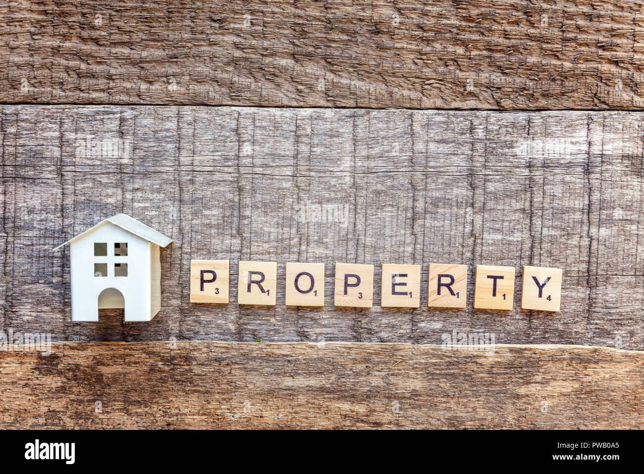 Miniature toy model house with inscription PROPERTY letters word on ...