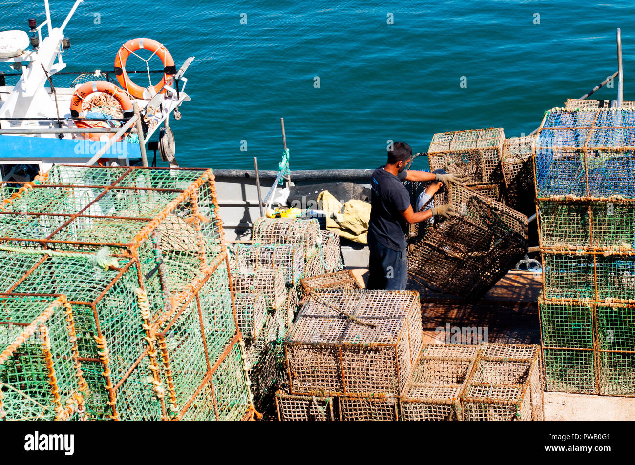 Fisherman packing up fishing traps for octopus Stock Photo - Alamy