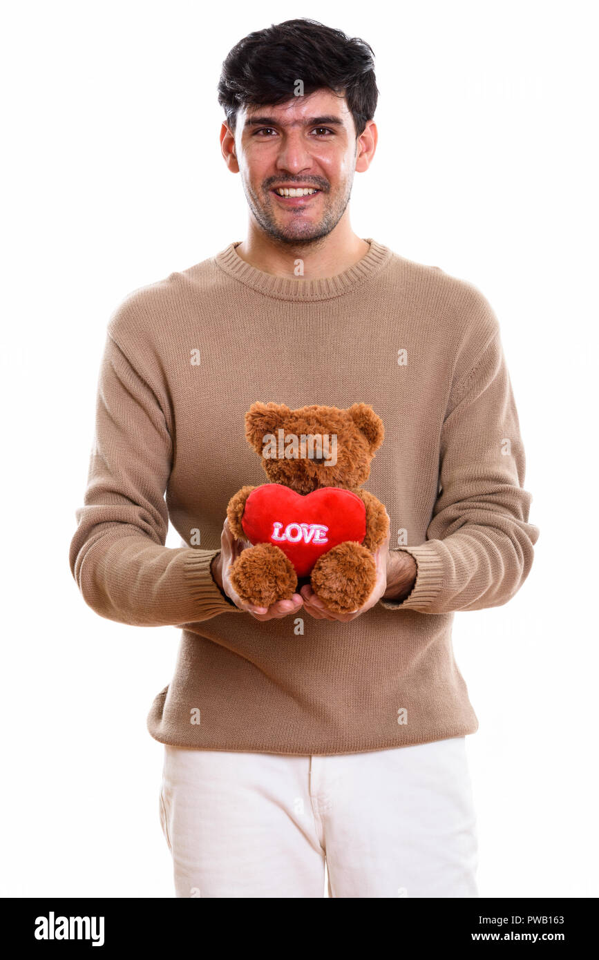 Young happy Persian man smiling while holding teddy bear with he Stock ...