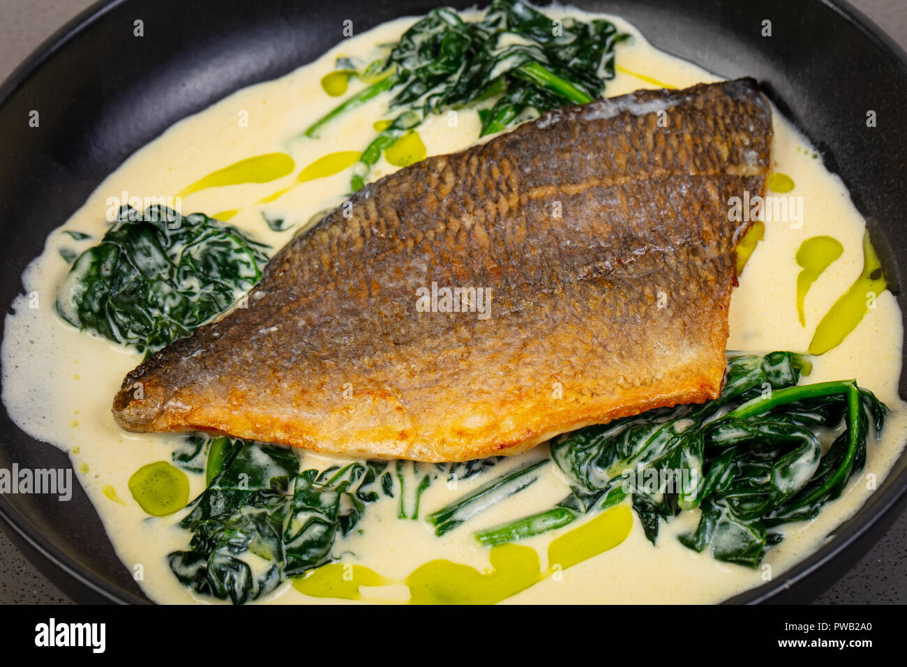 Dorada fish fillet with spinach Stock Photo - Alamy